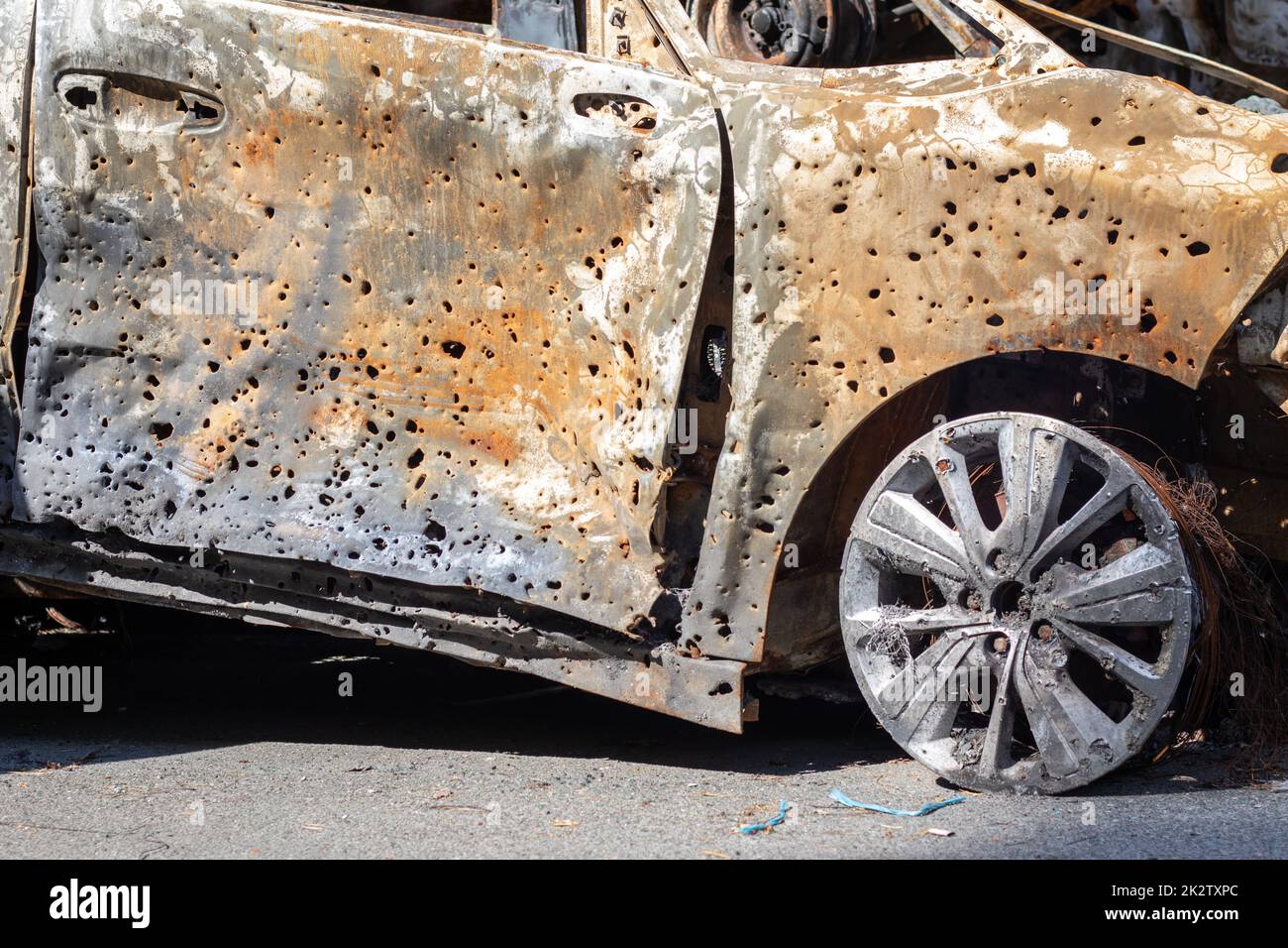 Burnt car body riddled with bullets. Russia's war against Ukraine. Shot ...