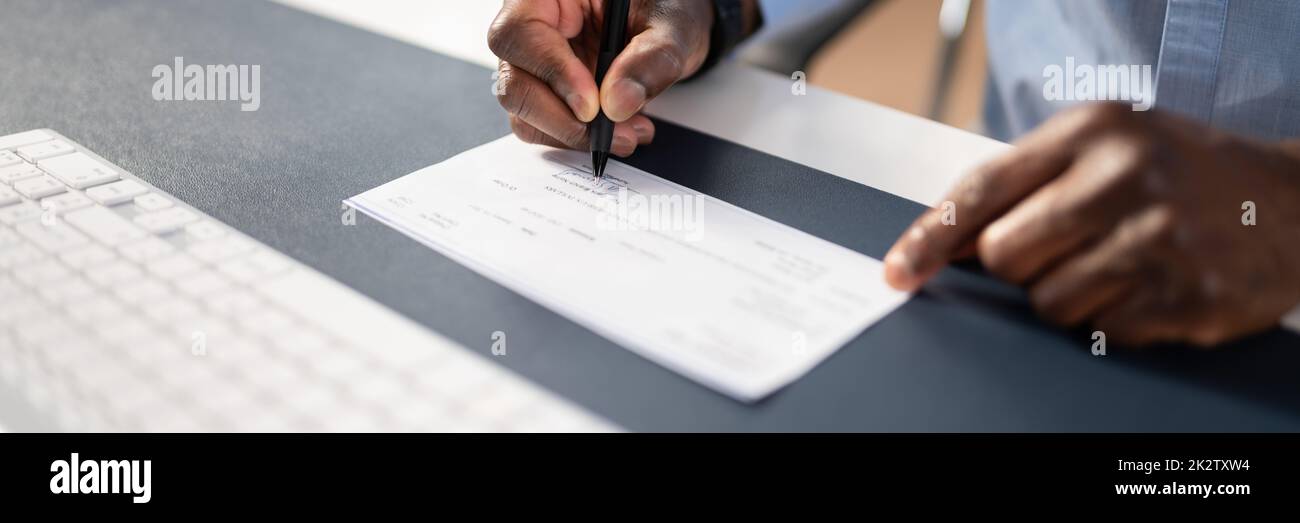 Businessperson Signing Cheque Stock Photo - Alamy