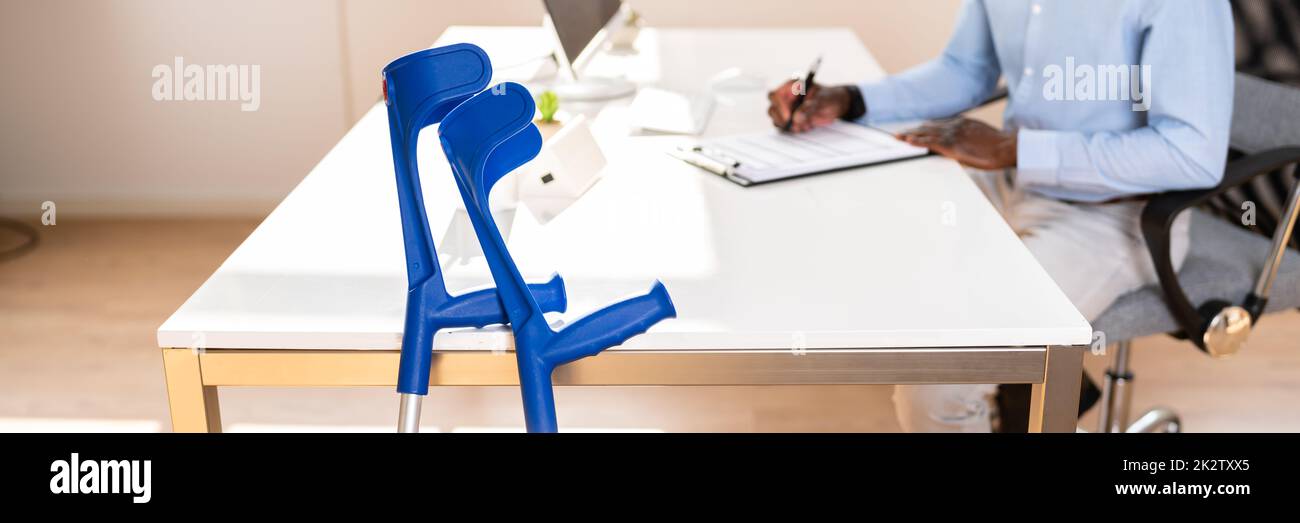 Crutches Leaning On Table In Front Of Disabled Patient Stock Photo - Alamy