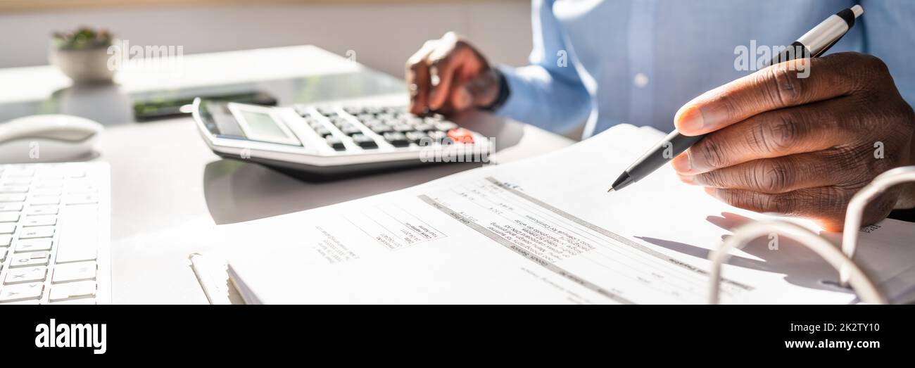 Smiling Businessman Calculating Invoice On Computer Stock Photo - Alamy