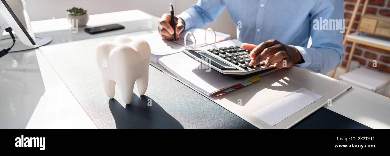 Tooth In Front Of Businessperson Calculating Bill Stock Photo - Alamy