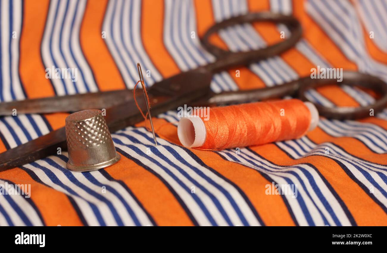Orange Thread and Thimble on Orange and White Striped Fabric Stock ...