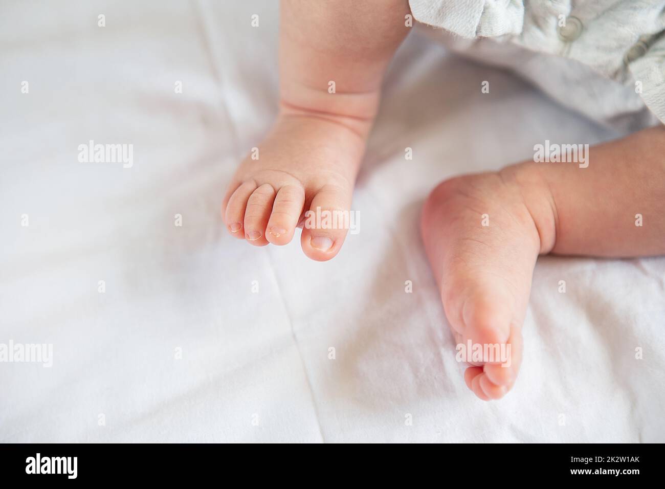 Small feet of a newborn baby on the bed, top view. The concept of ...