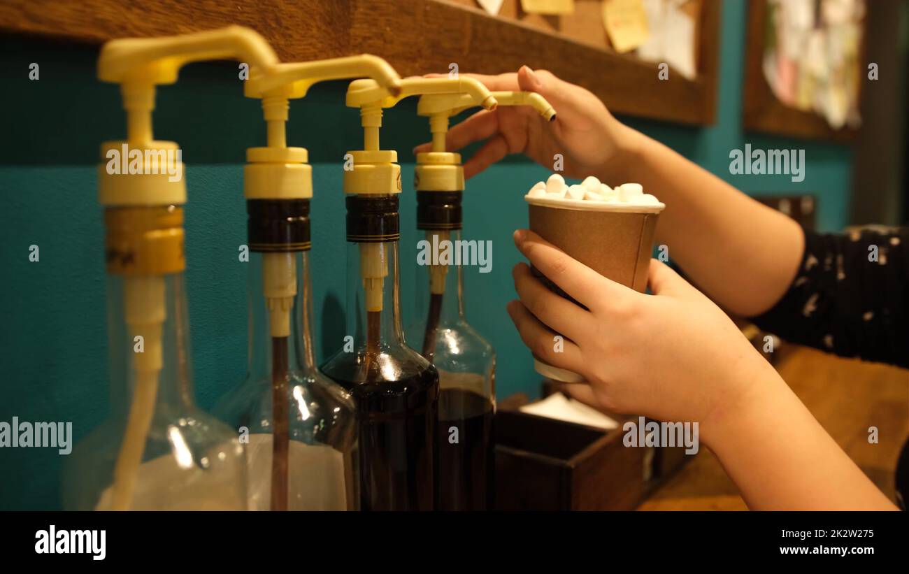 Author coffee, bartender before serving pours caramel syrup topping ...