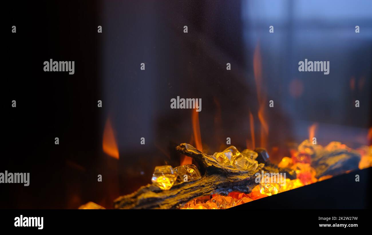 Side view on electric fireplace with artificial sparkling flame, decor ...