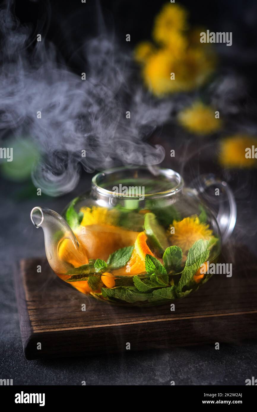 Glass teapot with fruit herbal tea. Advertising composition: tea with ...