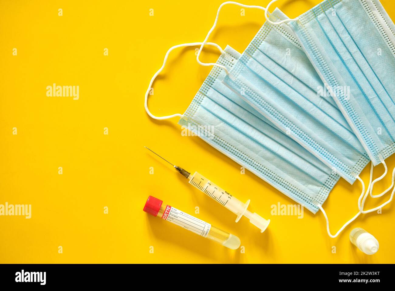 Medical protective mask and syringe on yellow background. Global ...