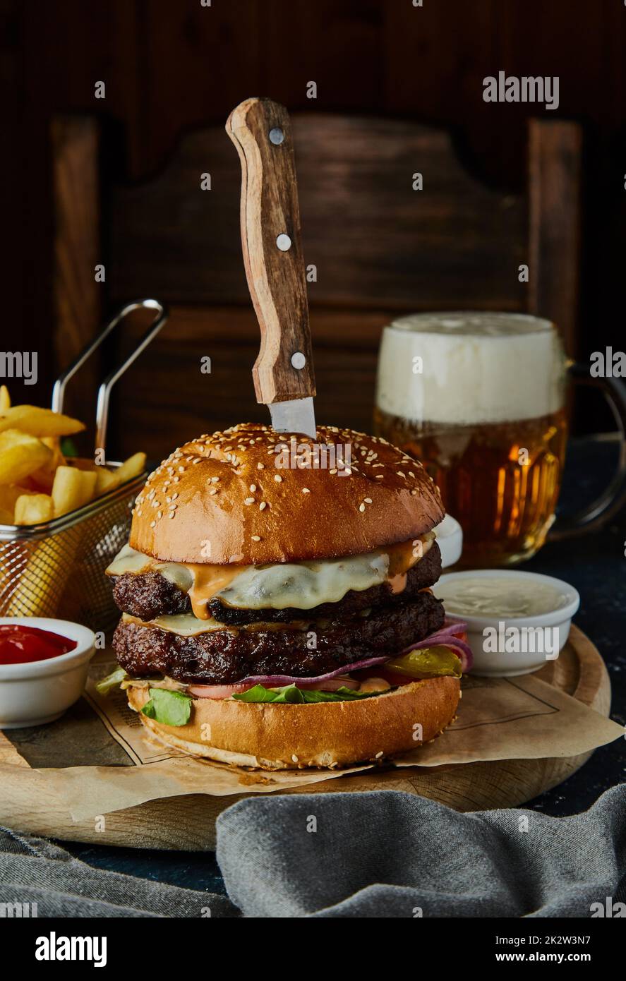 Double beef burger with egg, with fried potatoes and sauces on the ...
