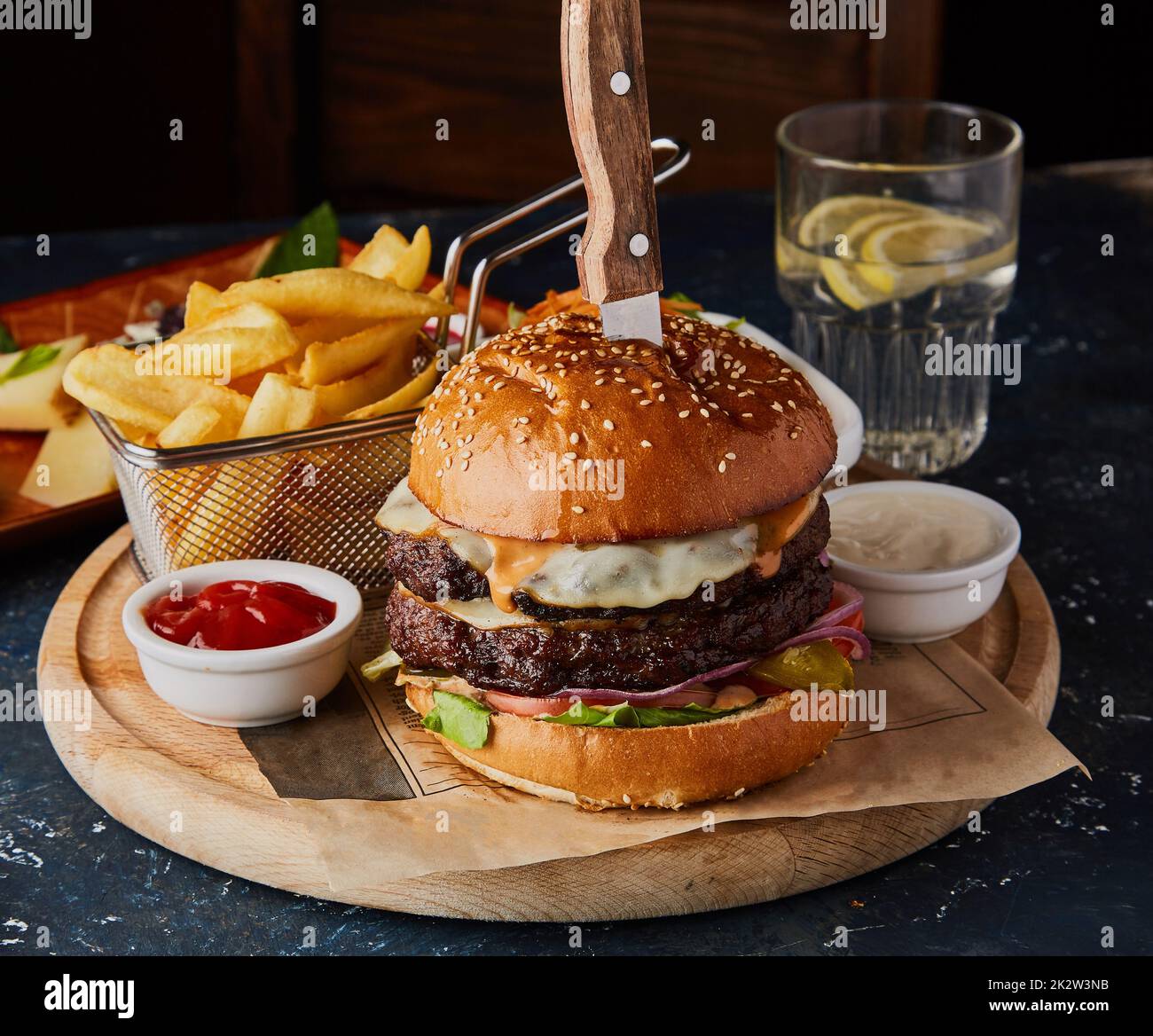 Double beef burger with egg, with fried potatoes and sauces on the ...