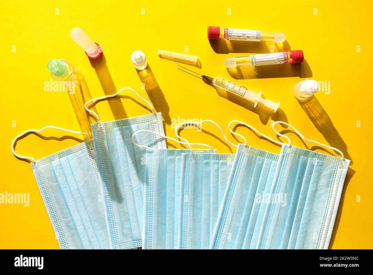 Medical protective mask and syringe on yellow background. Global ...
