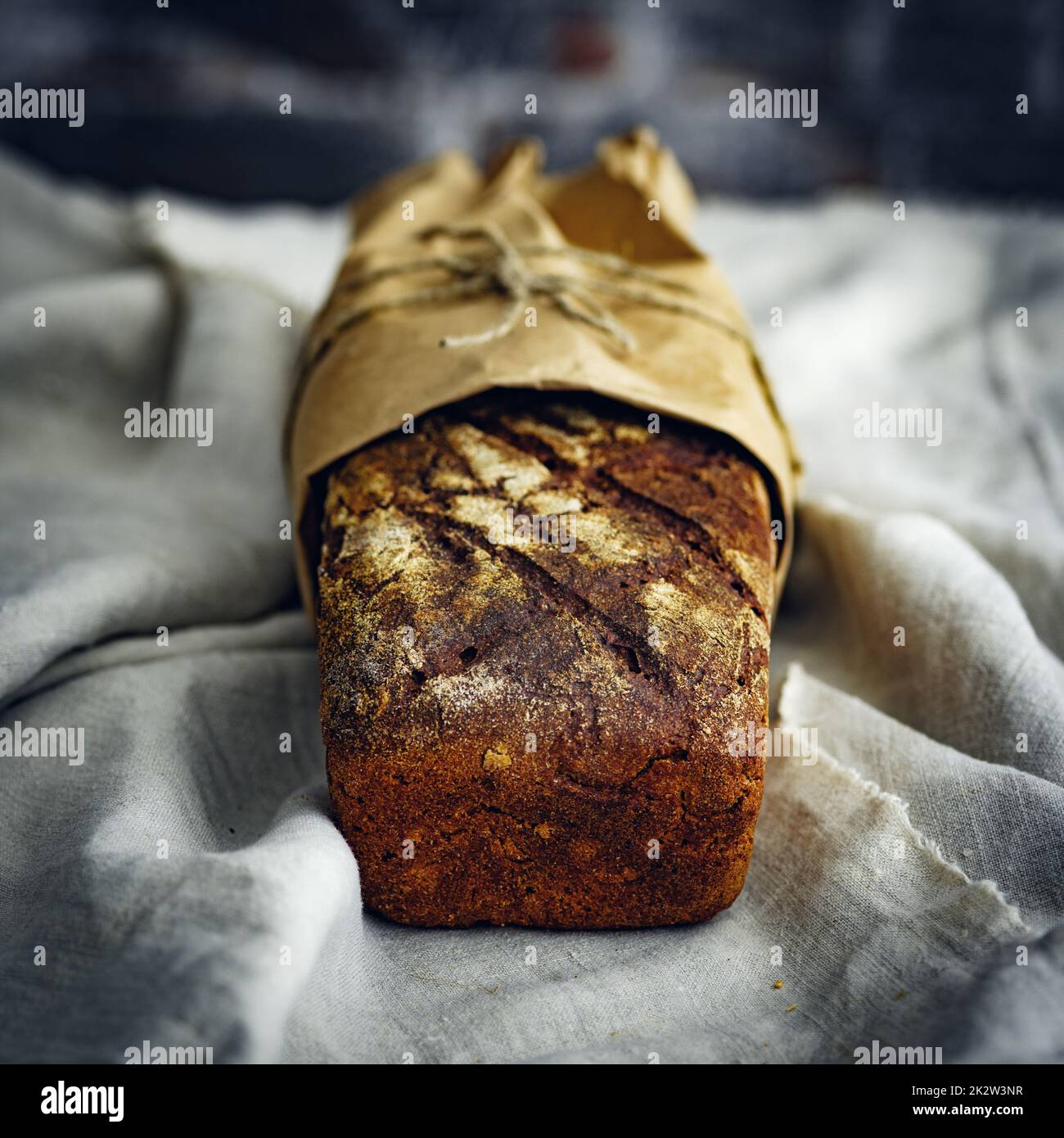 Homemade rye bread in the kraft paper on linen tablecloths Stock Photo ...