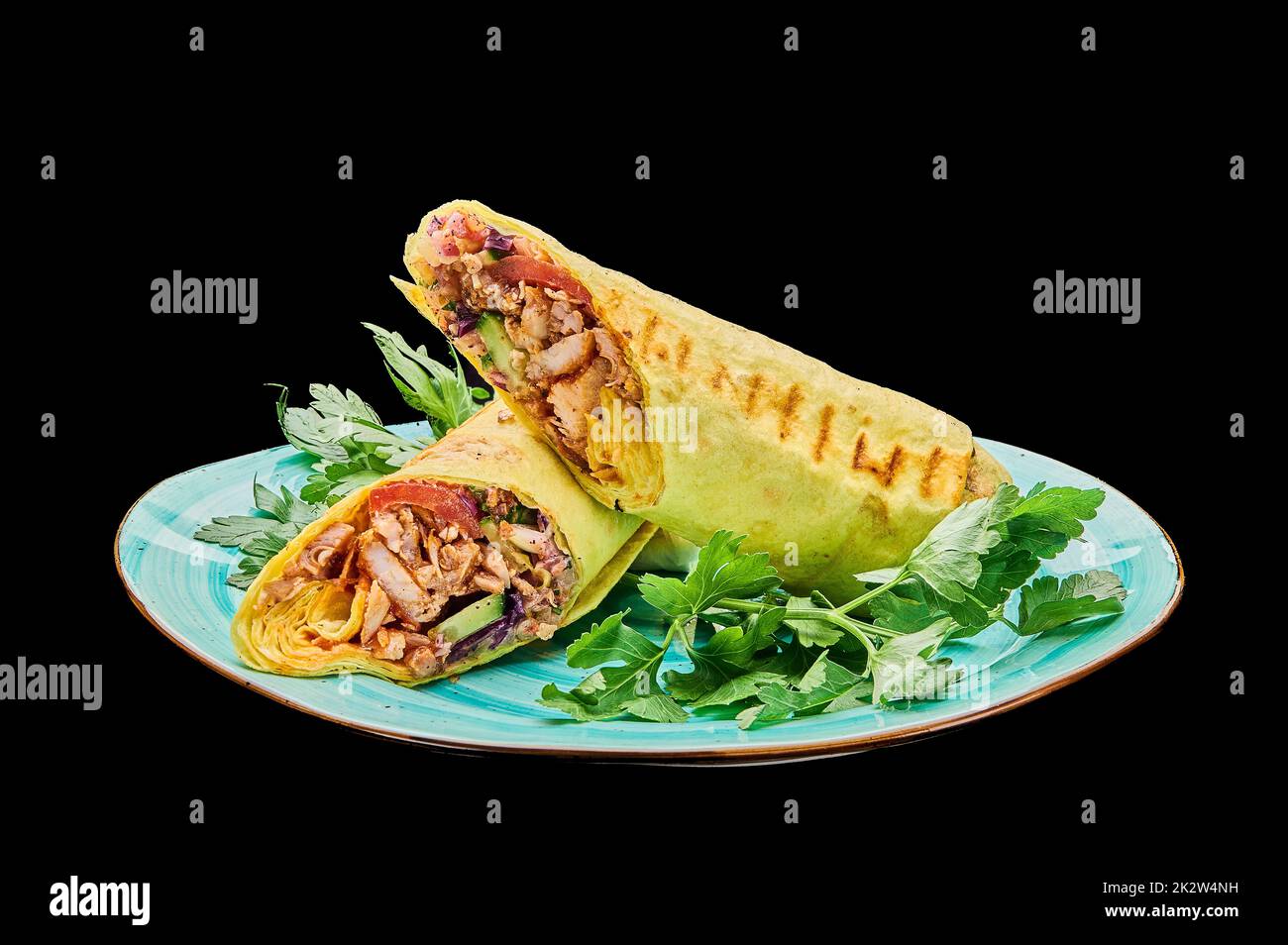 Chicken shawarma in cheese pita lies on a plate on a black isolated ...