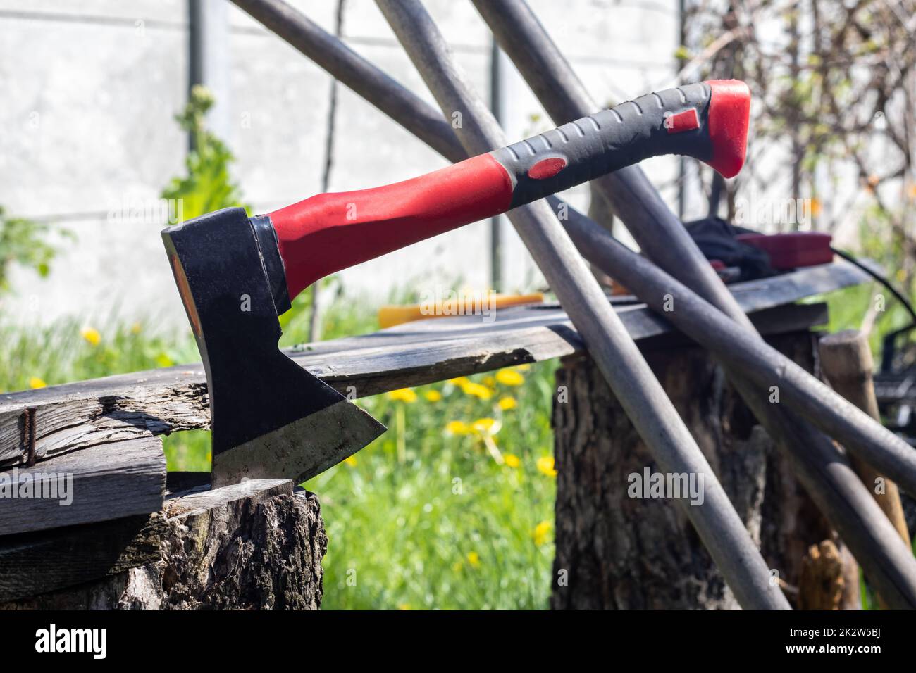An ax with a red handle plunges into a stump. Sawmill operation concept ...