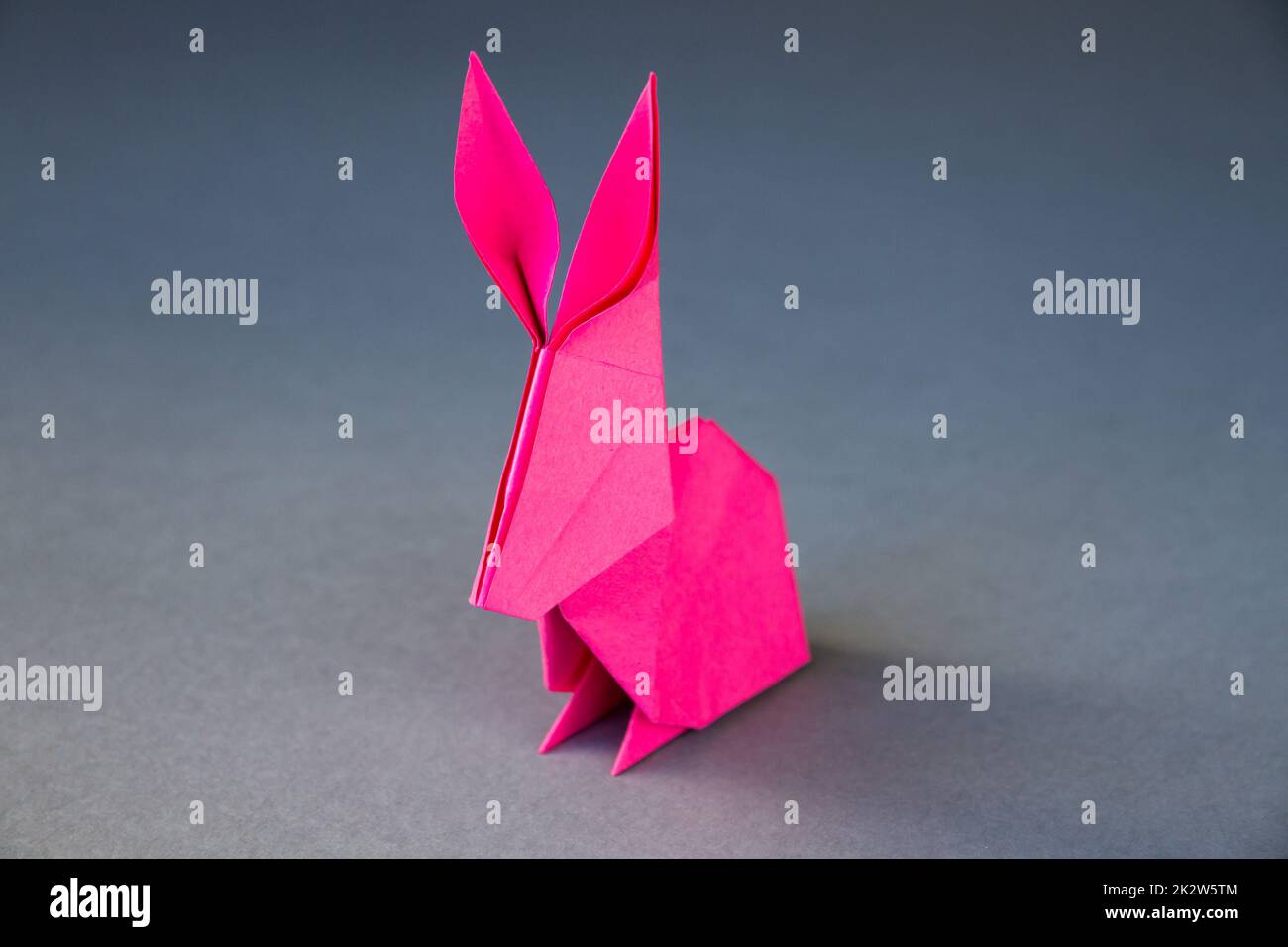 Pink paper rabbit origami isolated on a grey background Stock Photo - Alamy