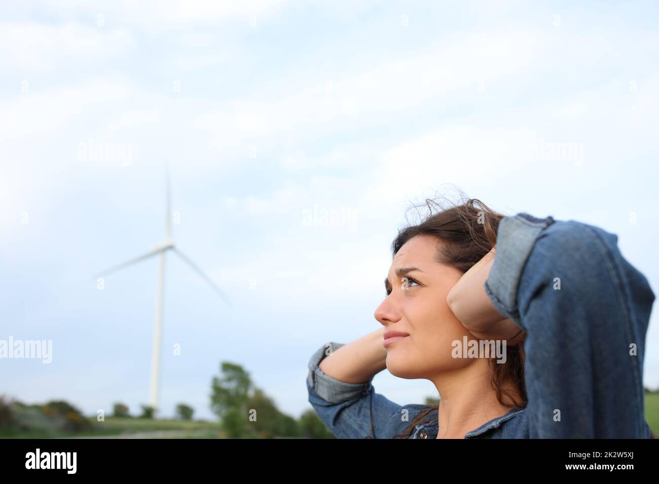 Annoyed woman suffering windmill noise in a wind farm Stock Photo - Alamy