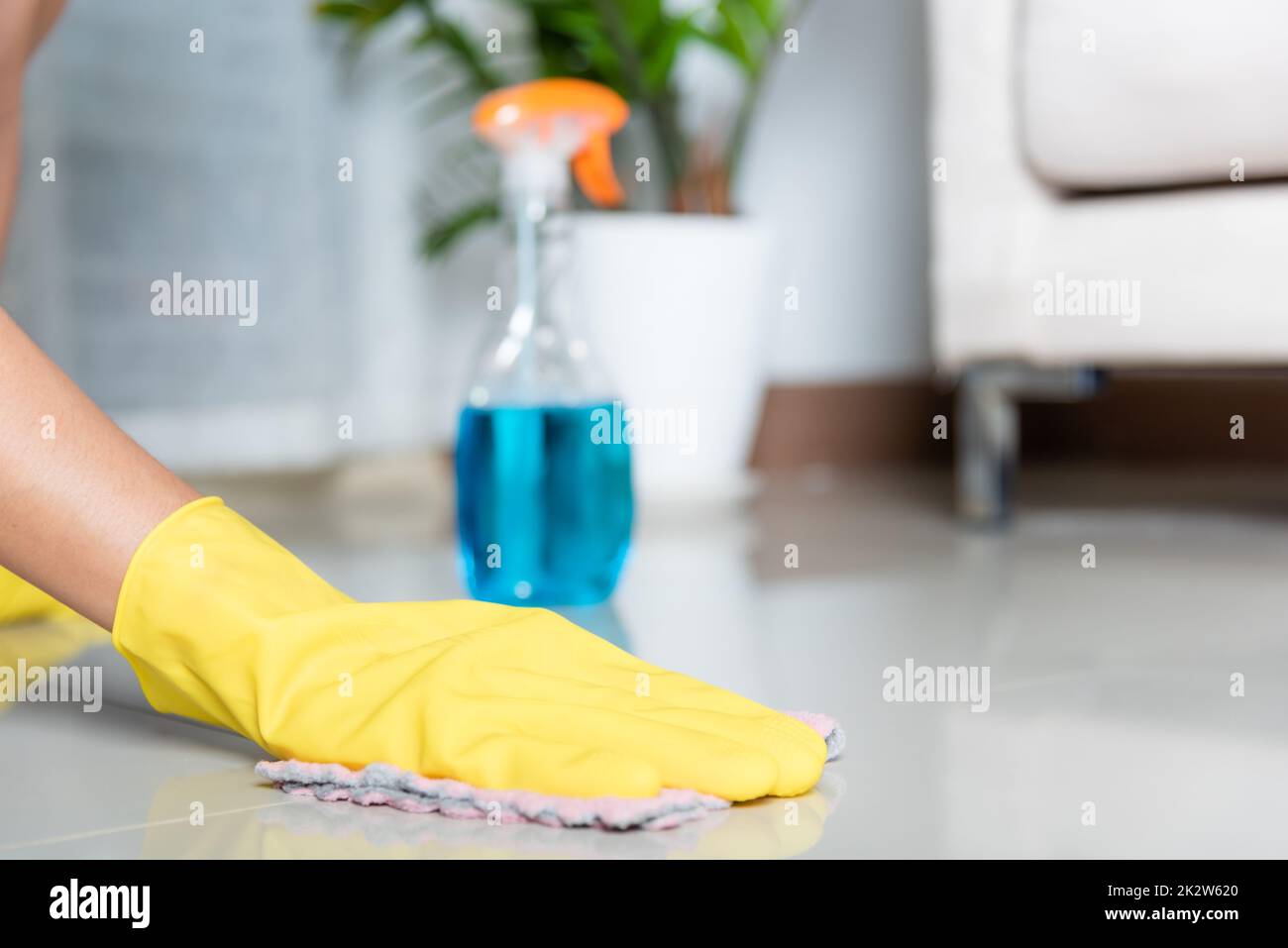 Asian woman wearing yellow rubber glover with cloth rag and detergent ...