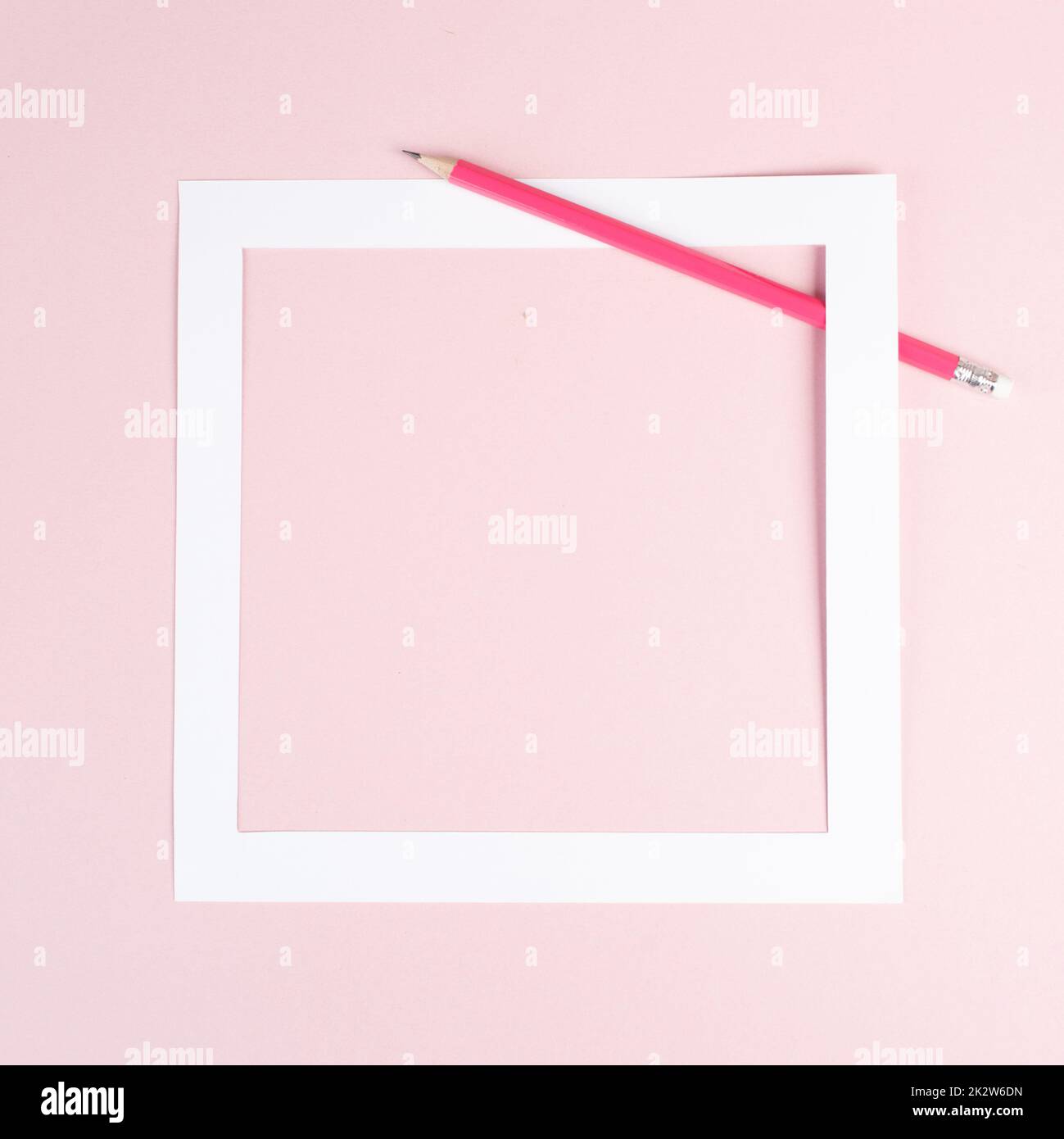 Pencil on a pink paper background, white frame with copy space for text ...