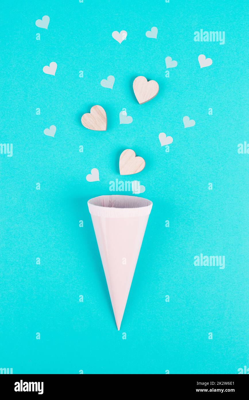 Cone with rose colored hearts, blue background, birthday and valentines ...