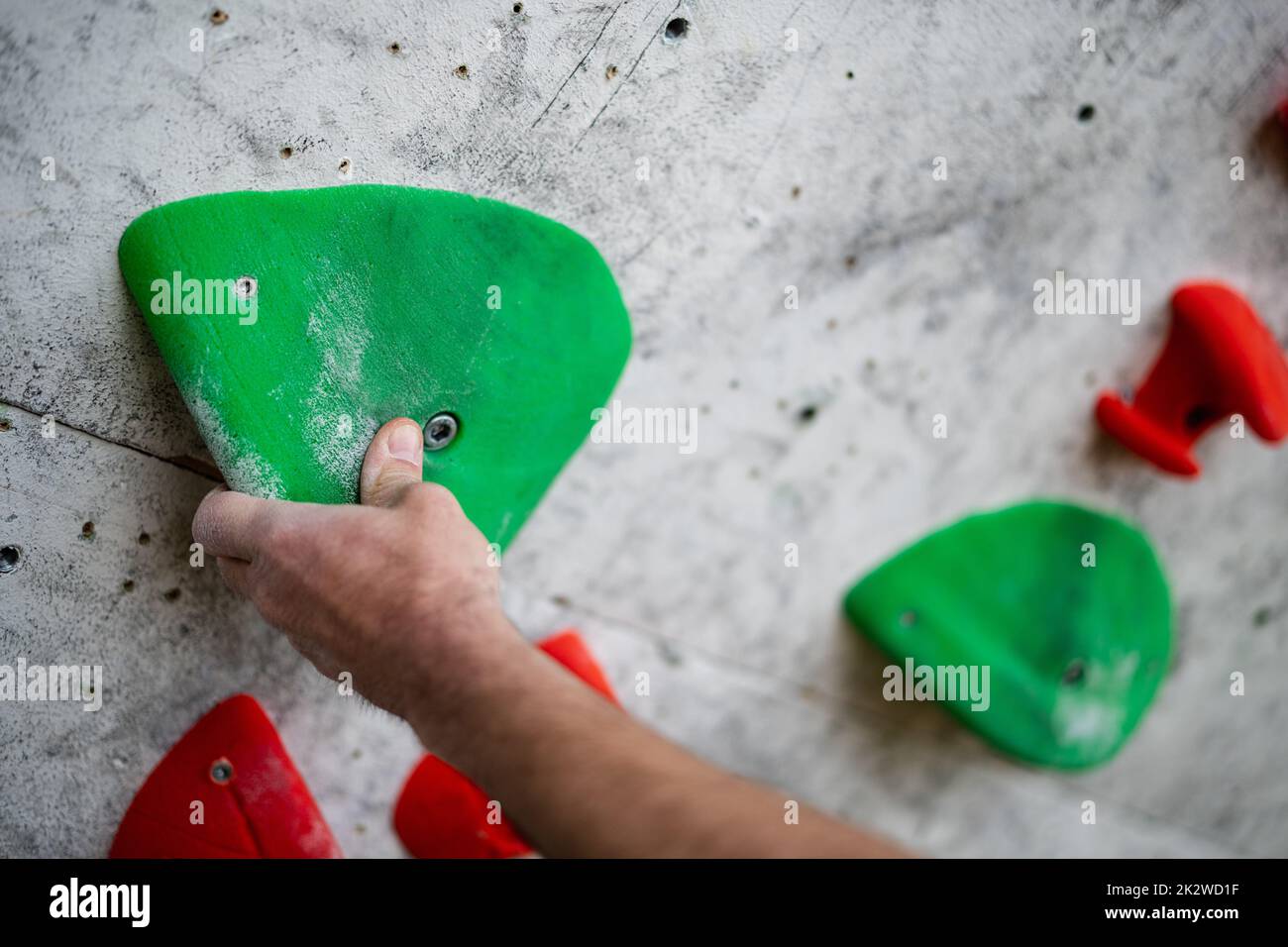 Male hands smeared with magnesium powder grabbing a hold of a climbing ...