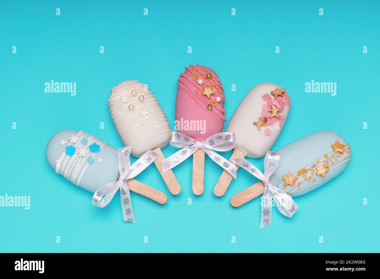 top view of decorated cake pops ice creams on turquoise background ...