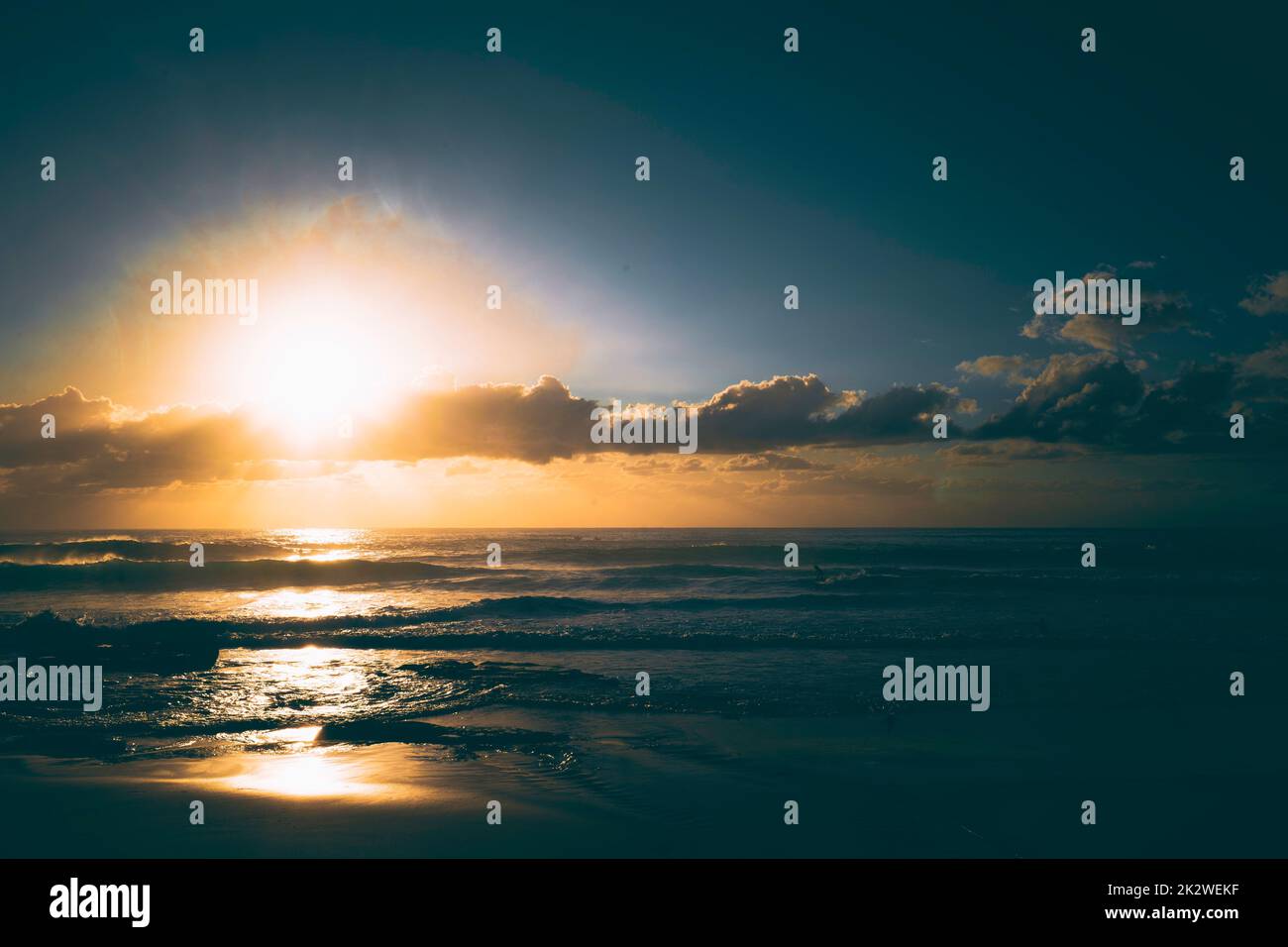 A bright golden sunset sky over a blue sea Stock Photo - Alamy
