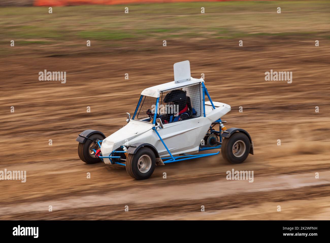 A small sports buggy racing vehicle with a child driving on a rally ...