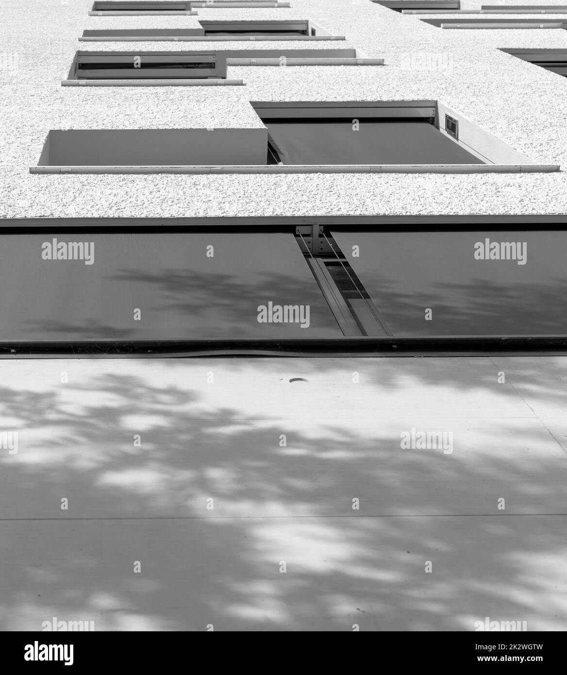 A low angle grayscale shot of a modern building design with black ...