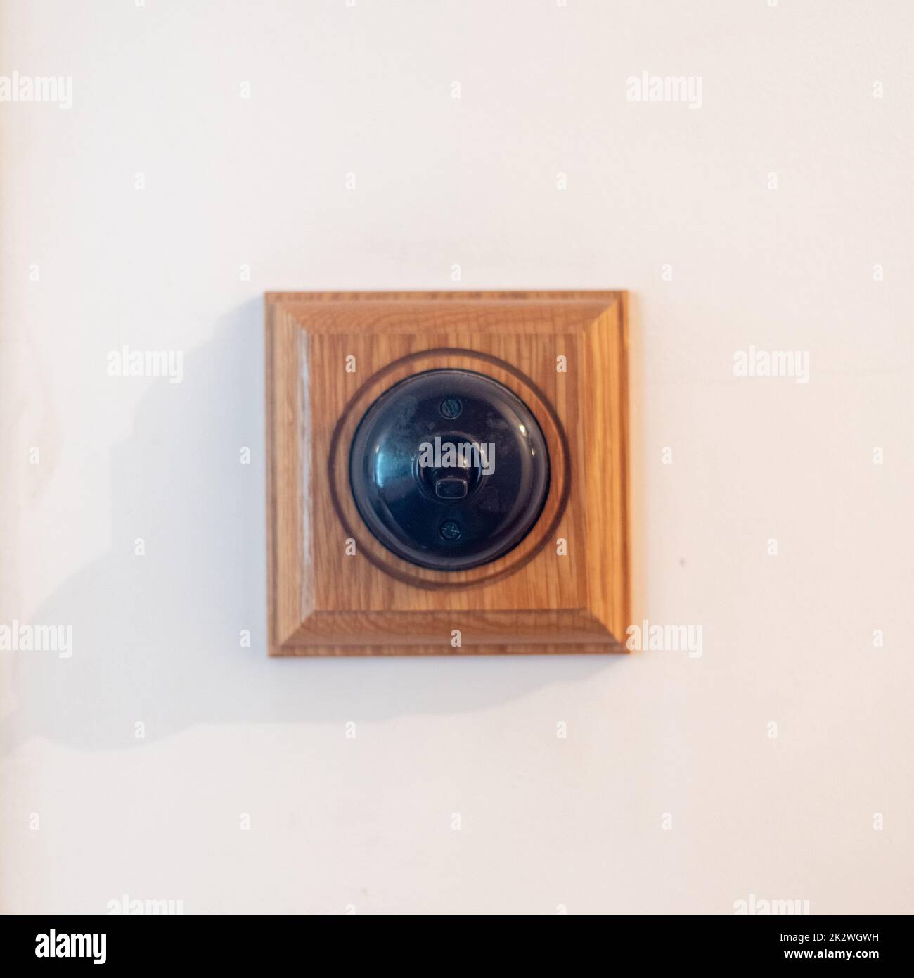 A wooden light switch on a white wall Stock Photo - Alamy