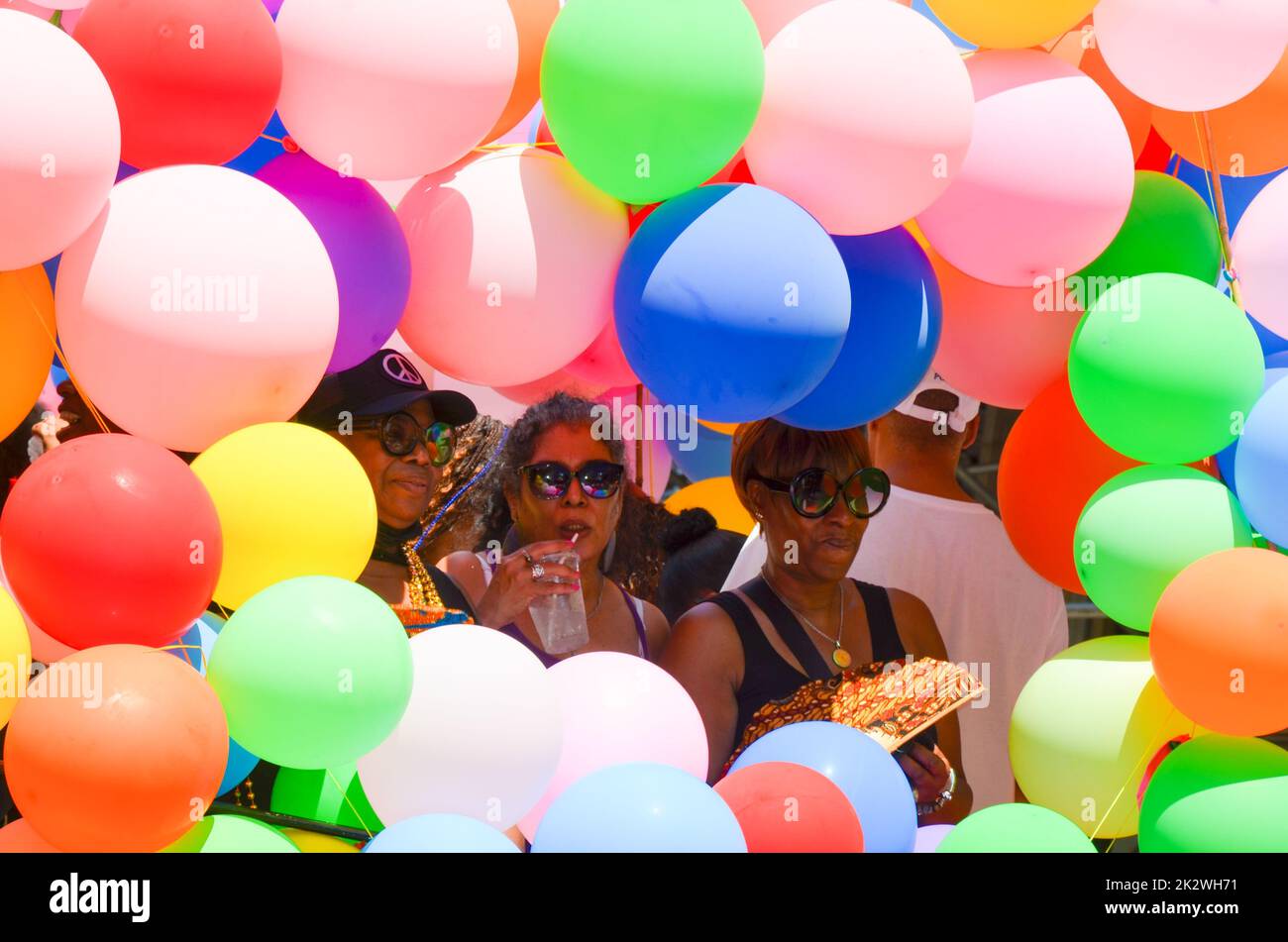 Three women surrounded by colorful balloons in Annual Dance Parade ...