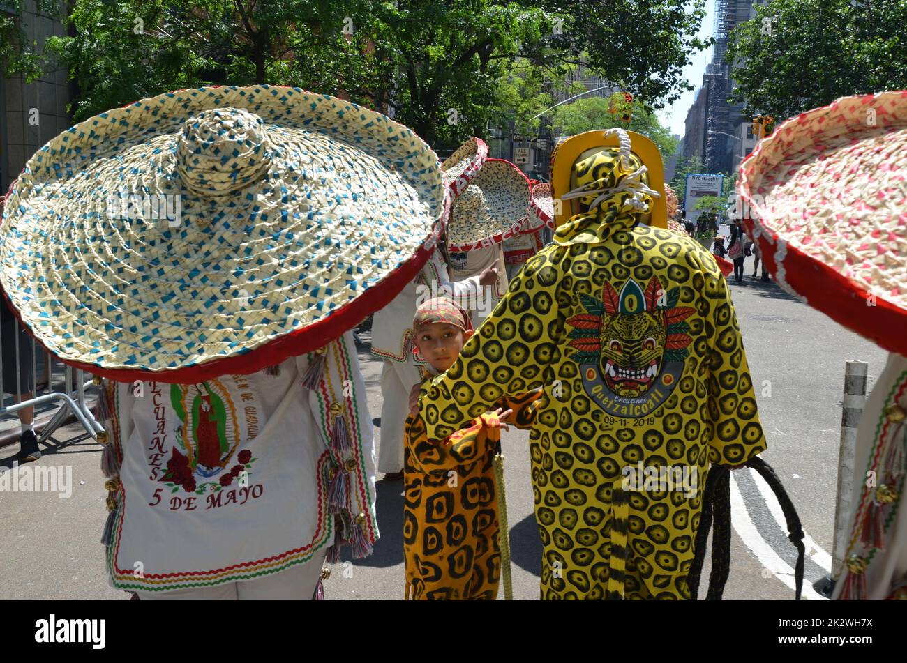 A child looking back while people walking wearing traditional hats in ...