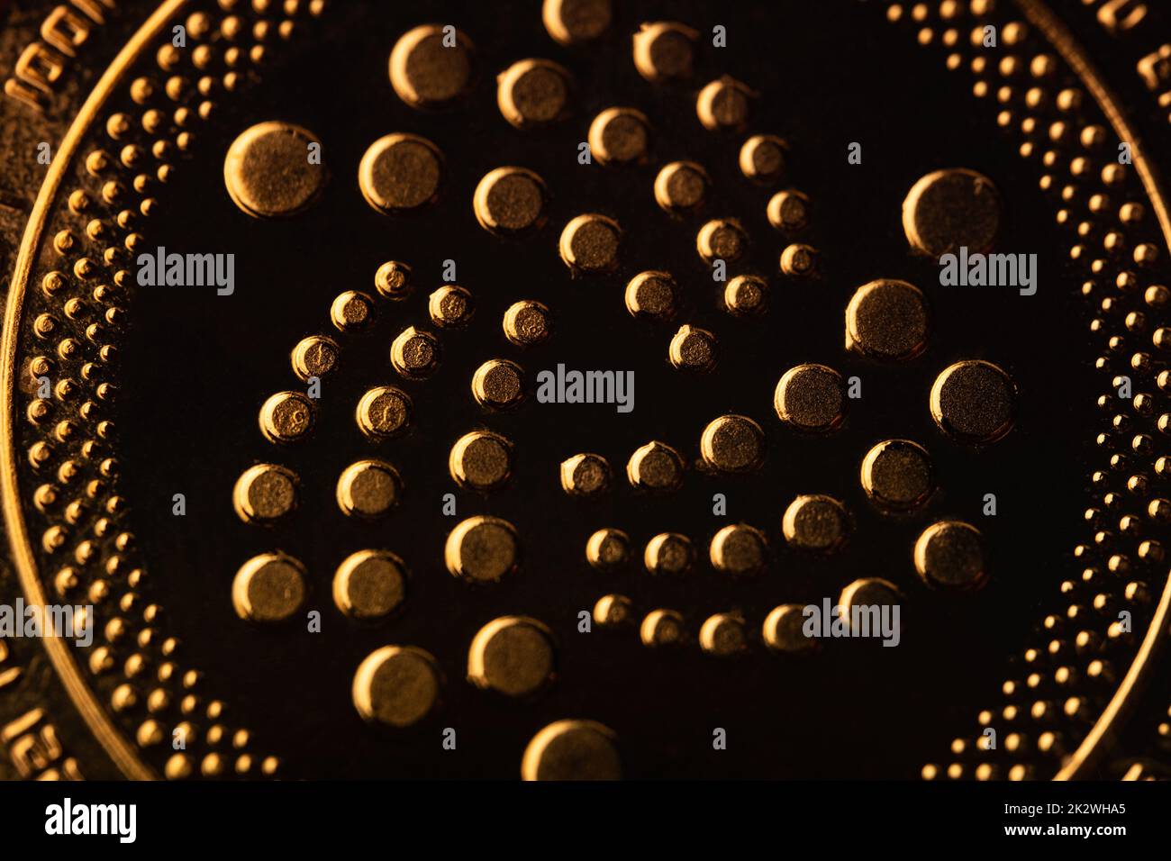 top view extreme macro closeup of crypto IOTA golden coin logo symbol ...