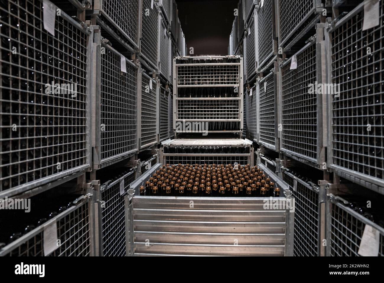 Glass bottles arranged in metallic storage containers at winery Stock ...