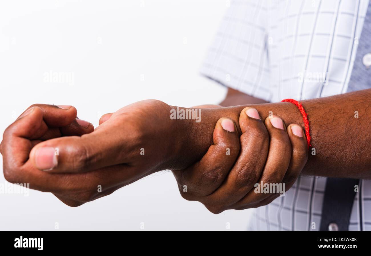 black man holds his wrist hand injury, feeling pain Stock Photo - Alamy