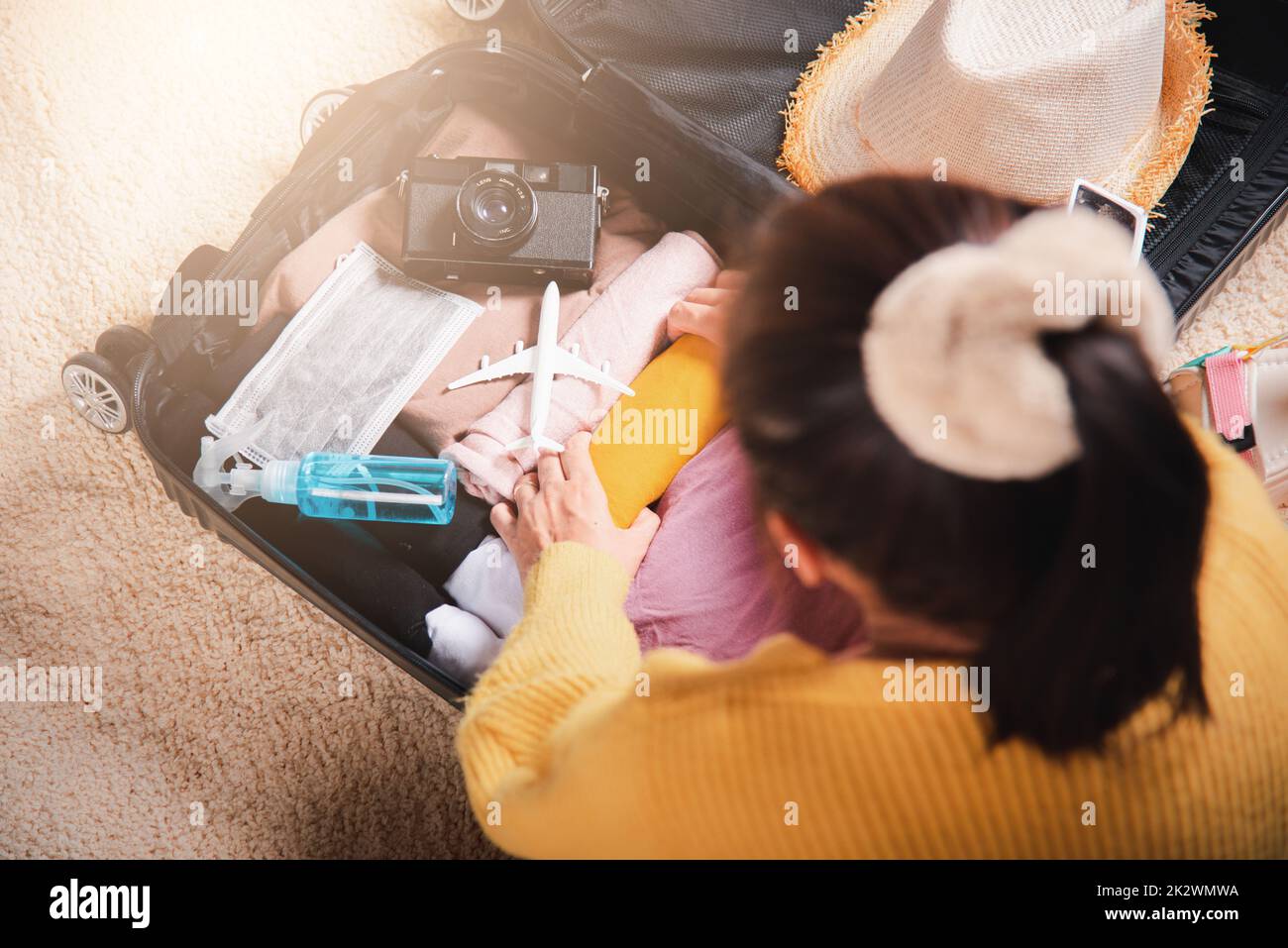 Woman packing clothes in luggage for new journey Stock Photo - Alamy