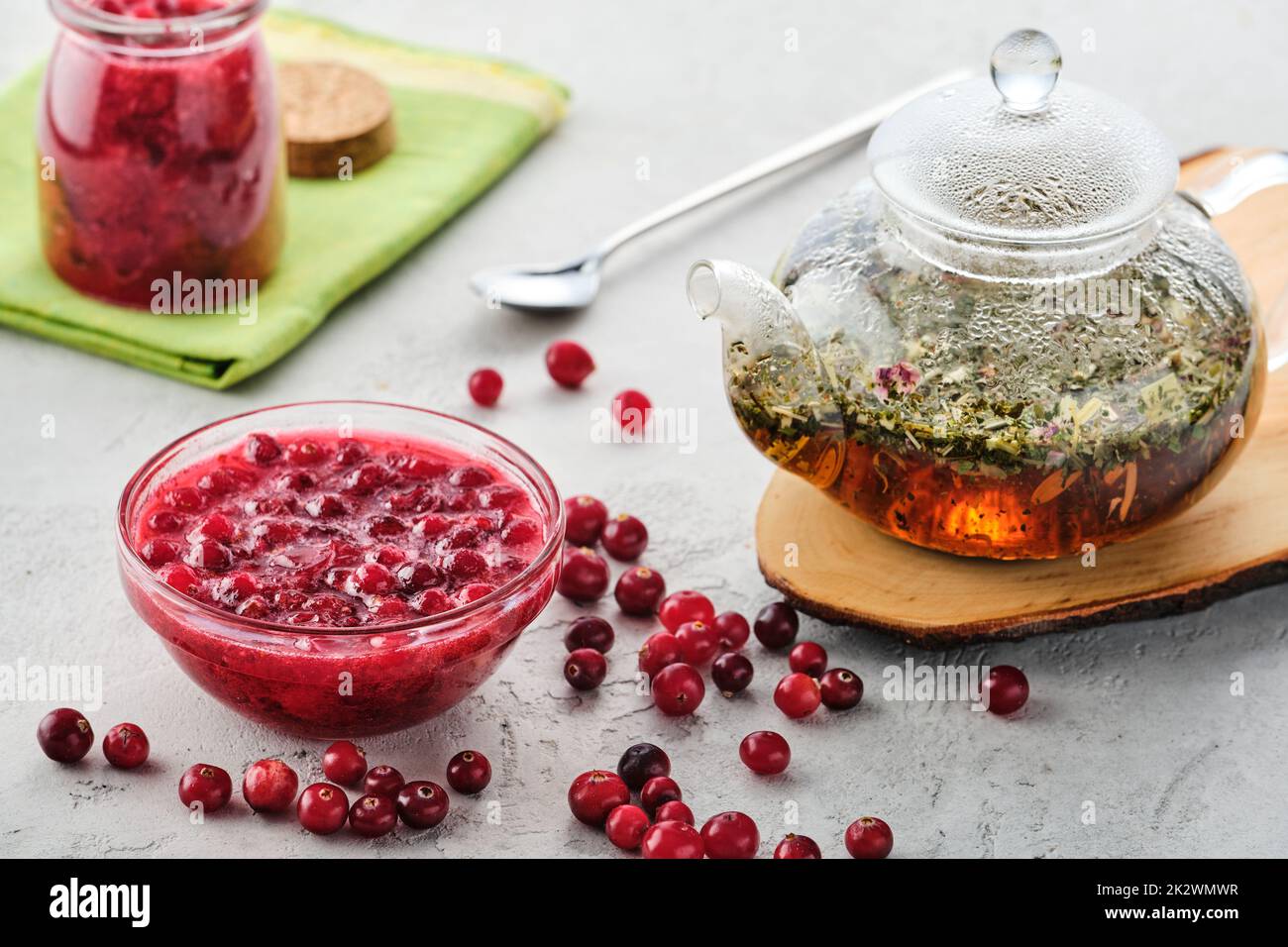 Cranberry jam in a glass bowl and teapot on a white background Stock ...