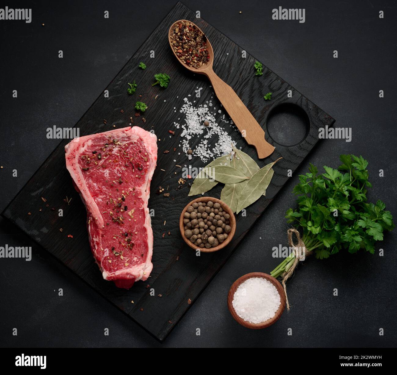 Fresh raw piece of beef meat, striploin steak on a black background ...