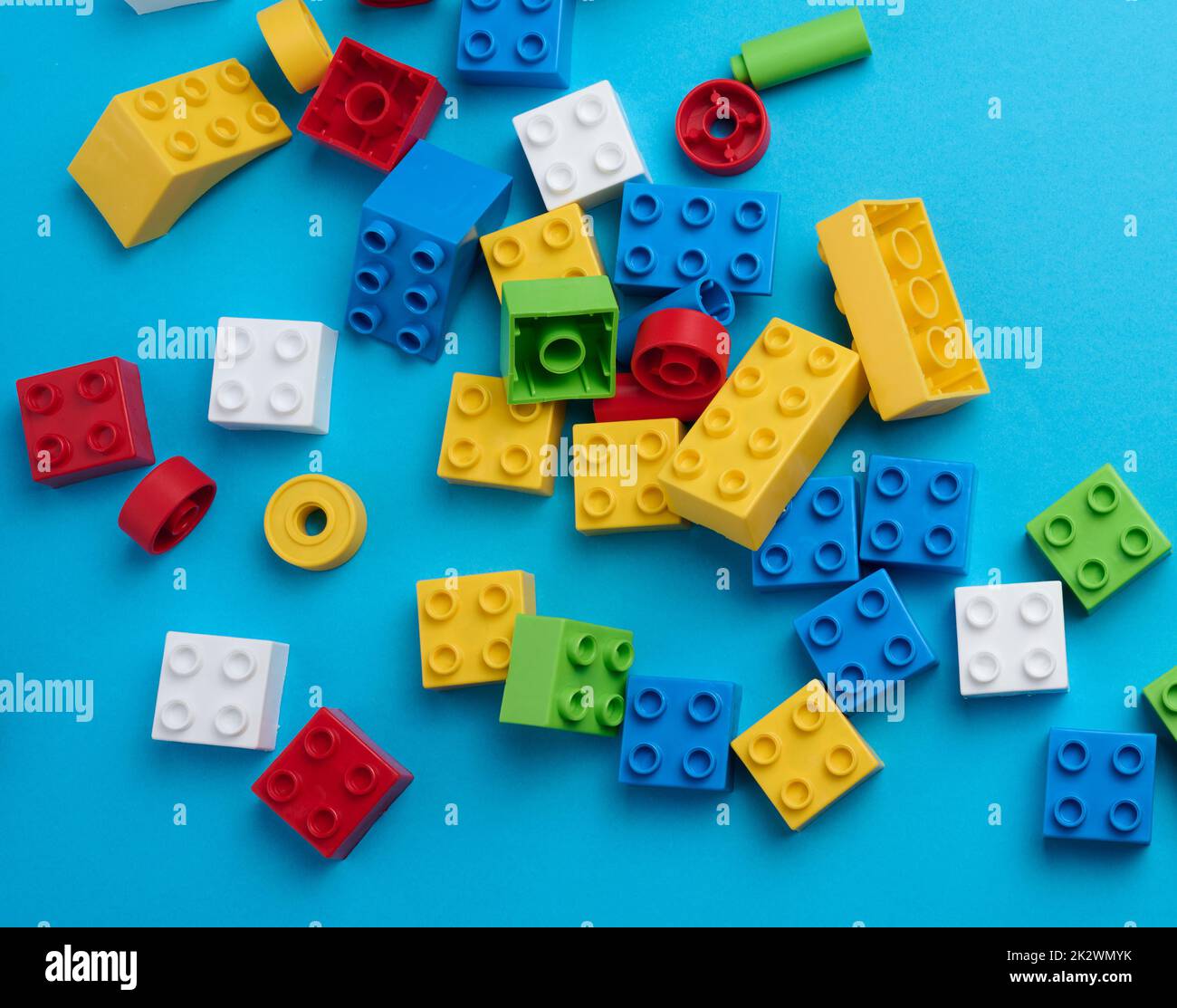 Scattered parts of a plastic children's designer, top view. Yellow blue ...