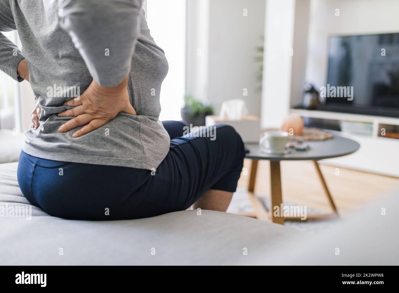 Elderly woman at home with back pain Stock Photo - Alamy