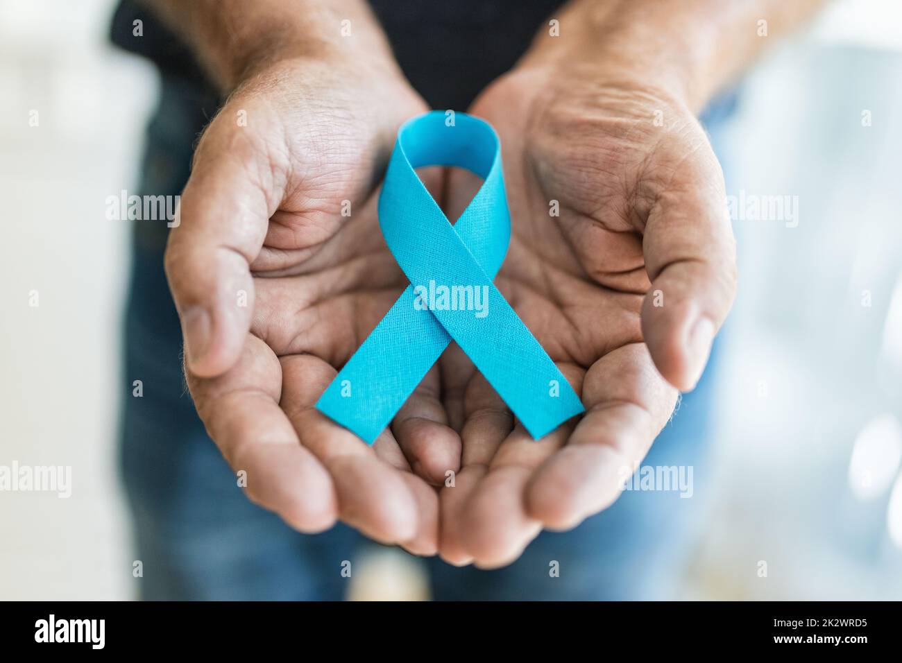 Senior man holding a blue cancer awareness ribbon Stock Photo - Alamy