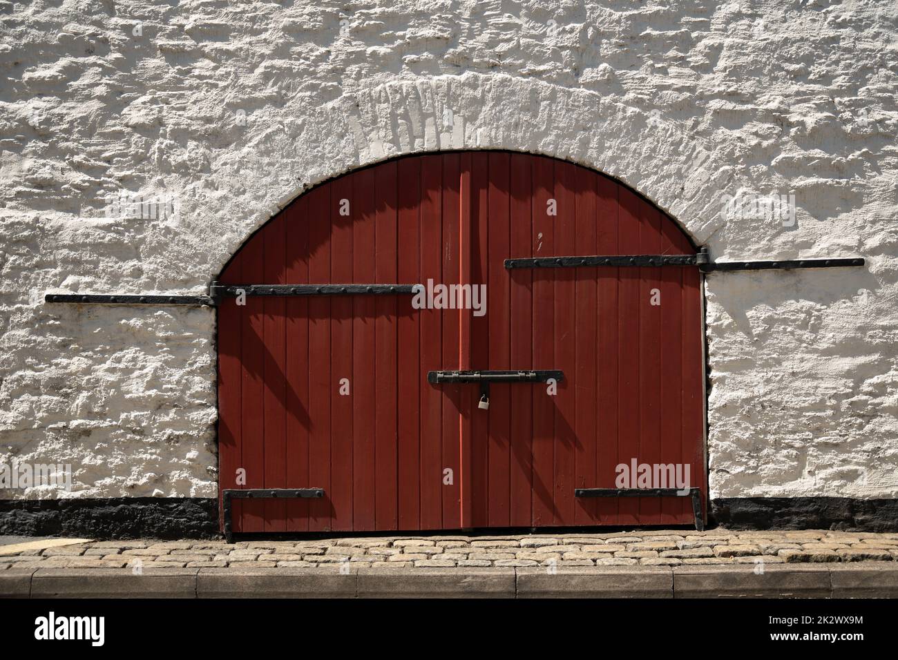The arching wooden doors secured by locks on an old medieval castle in ...