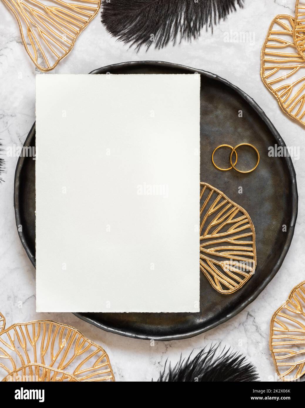 Black and golden wedding table setting with a blank card and rings top ...