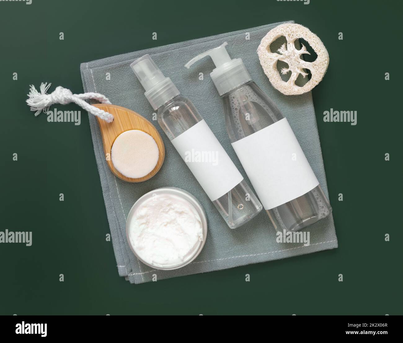 Homemade Cosmetics in plastic jars and bottles on grey towel top view ...