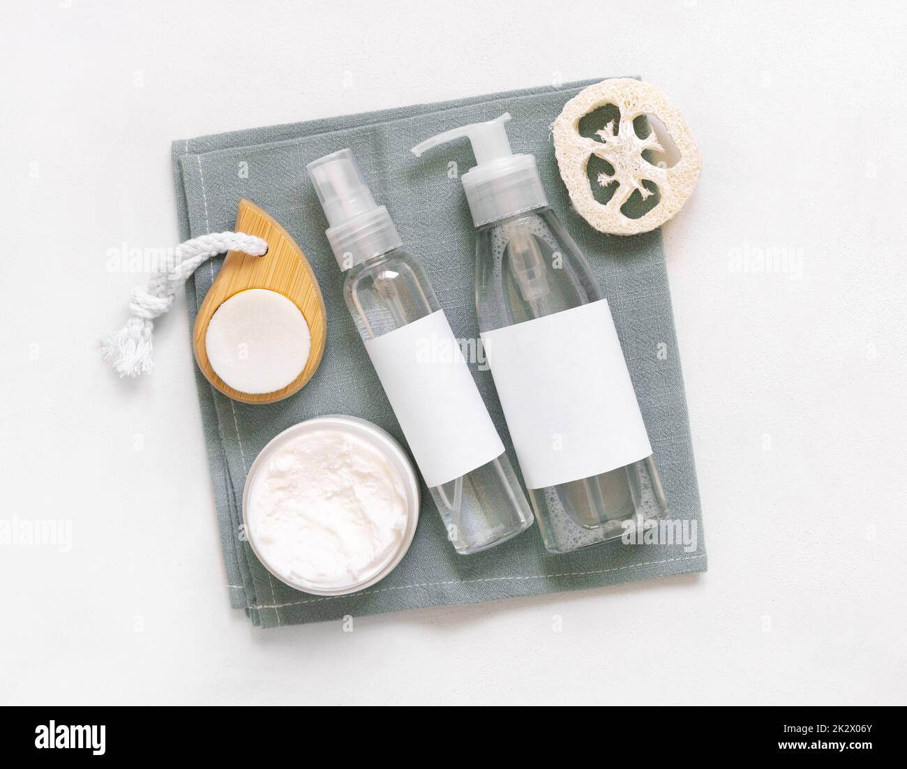 Homemade Cosmetics in plastic jars and bottles on grey towel top view ...
