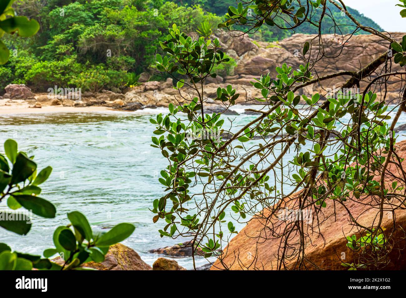 Deserted beach and the sea hidden between the rocks and the rainforest ...