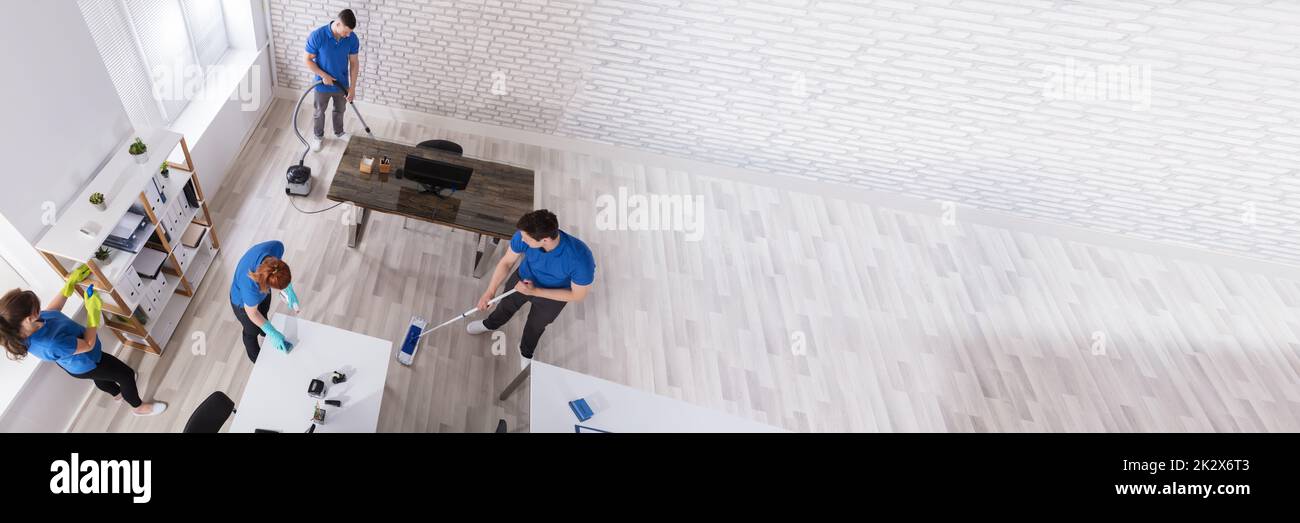 Group Of Janitors Cleaning The Office Stock Photo - Alamy