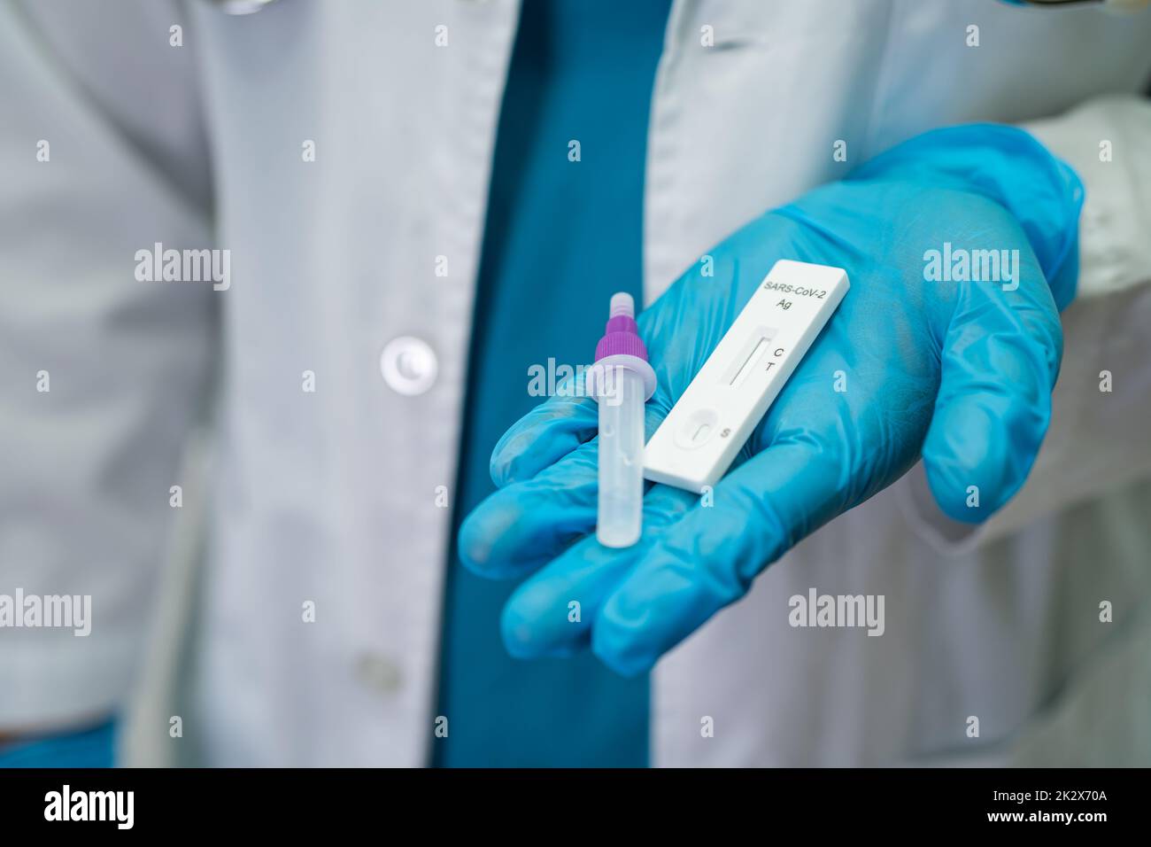 Asian doctor in PPE suit holding Saliva Antigen Test Kit for check ...