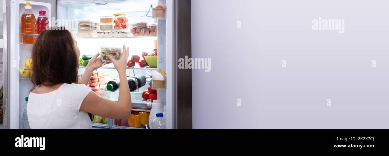 Woman Taking Food From Refrigerator Stock Photo - Alamy
