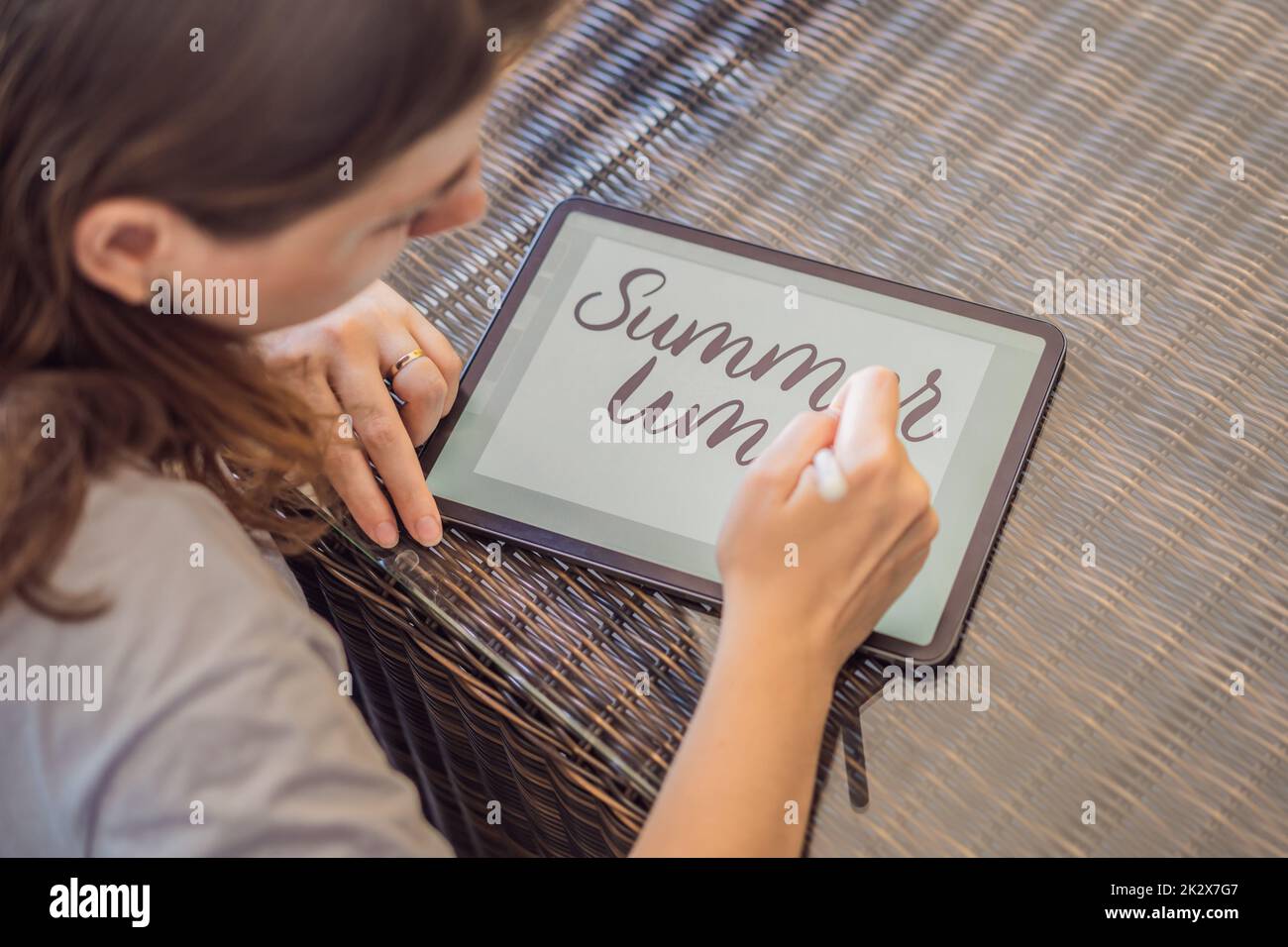 Calligrapher Young Woman writes phrase on digital tablet. Inscribing ...