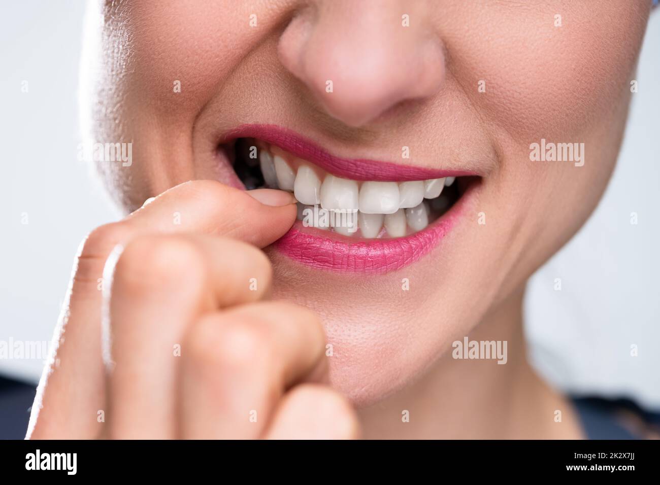 Businesswoman Biting Her Fingernail Stock Photo - Alamy