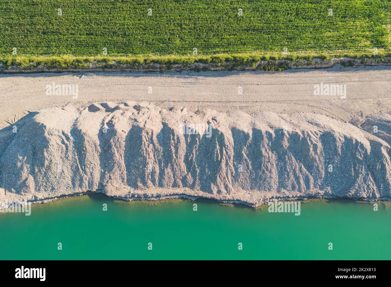 Landfill of the mined white fine aggregate between the turquoise lake ...